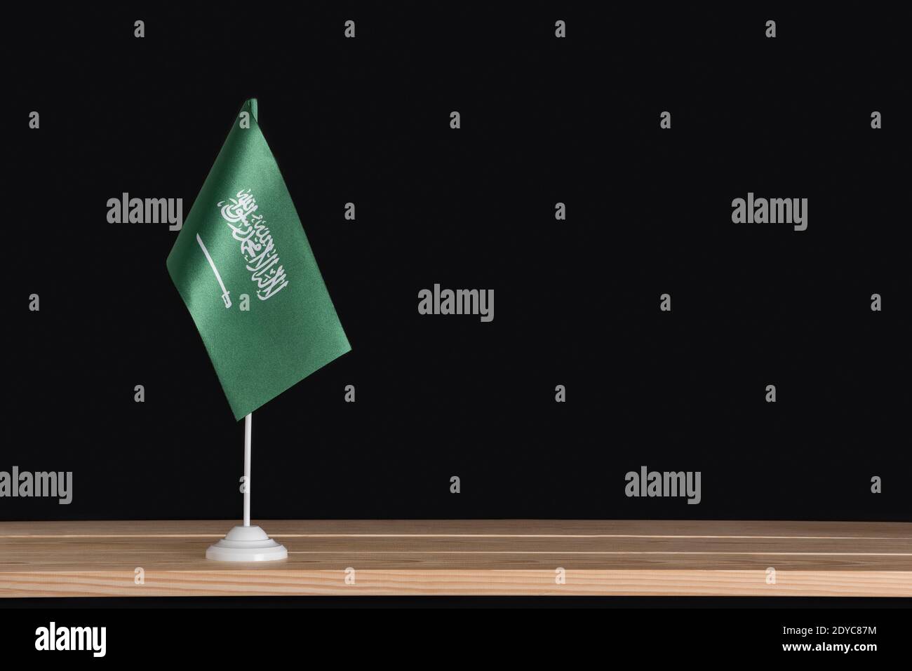 National flag of Saudi Arabia on table, black background. Green flag ...