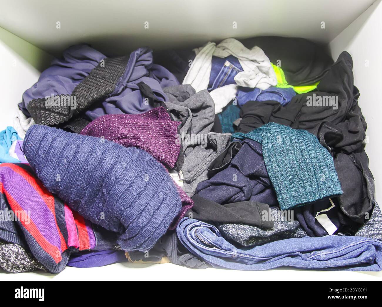 Home wardrobe with different clothes in disorder. Small space ...