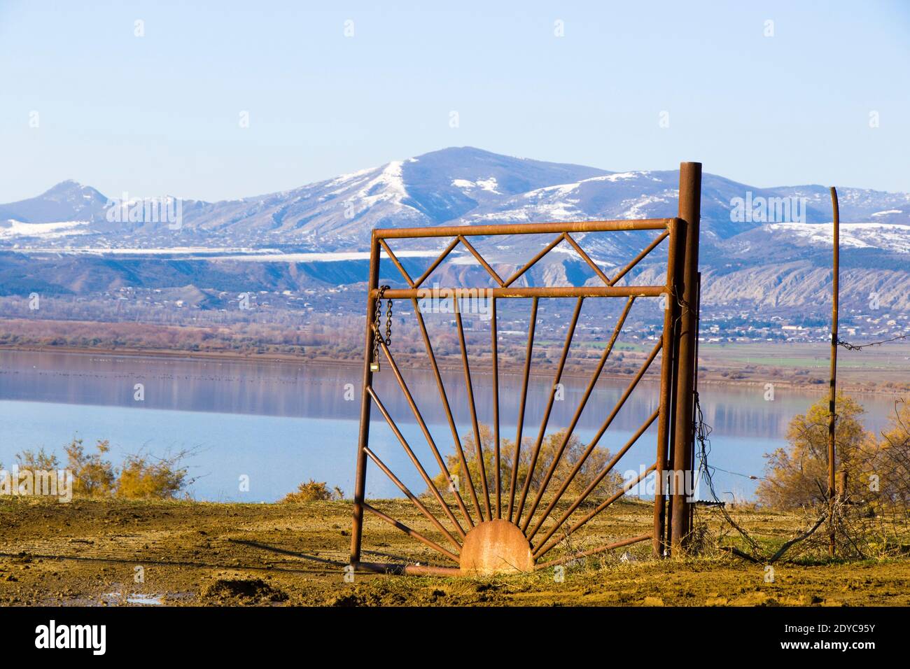 Iron gate and mountain lake view Stock Photo - Alamy