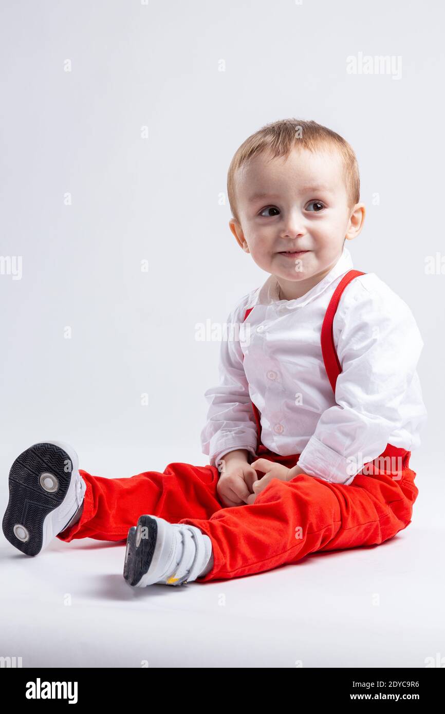 Pretty little boy, dressed in red on white background. Boy and ...