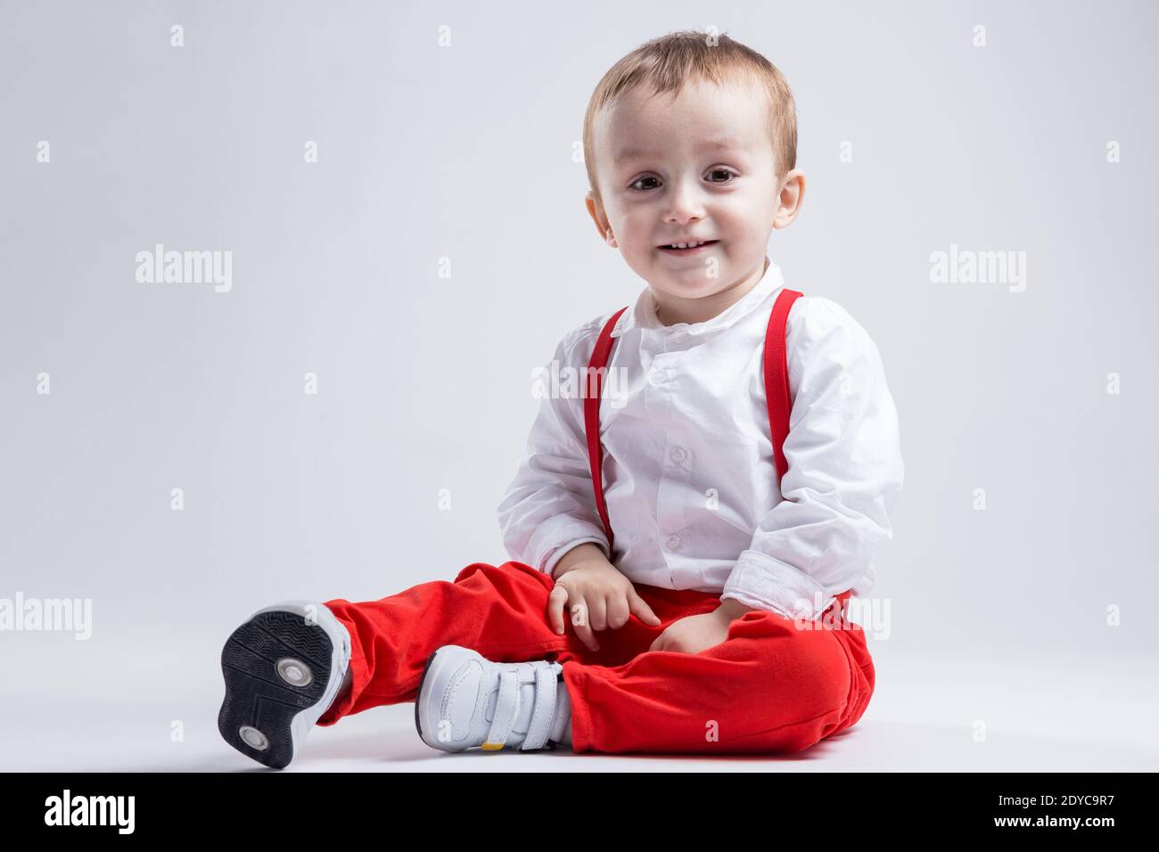 Pretty little boy, dressed in red on white background. Boy and ...