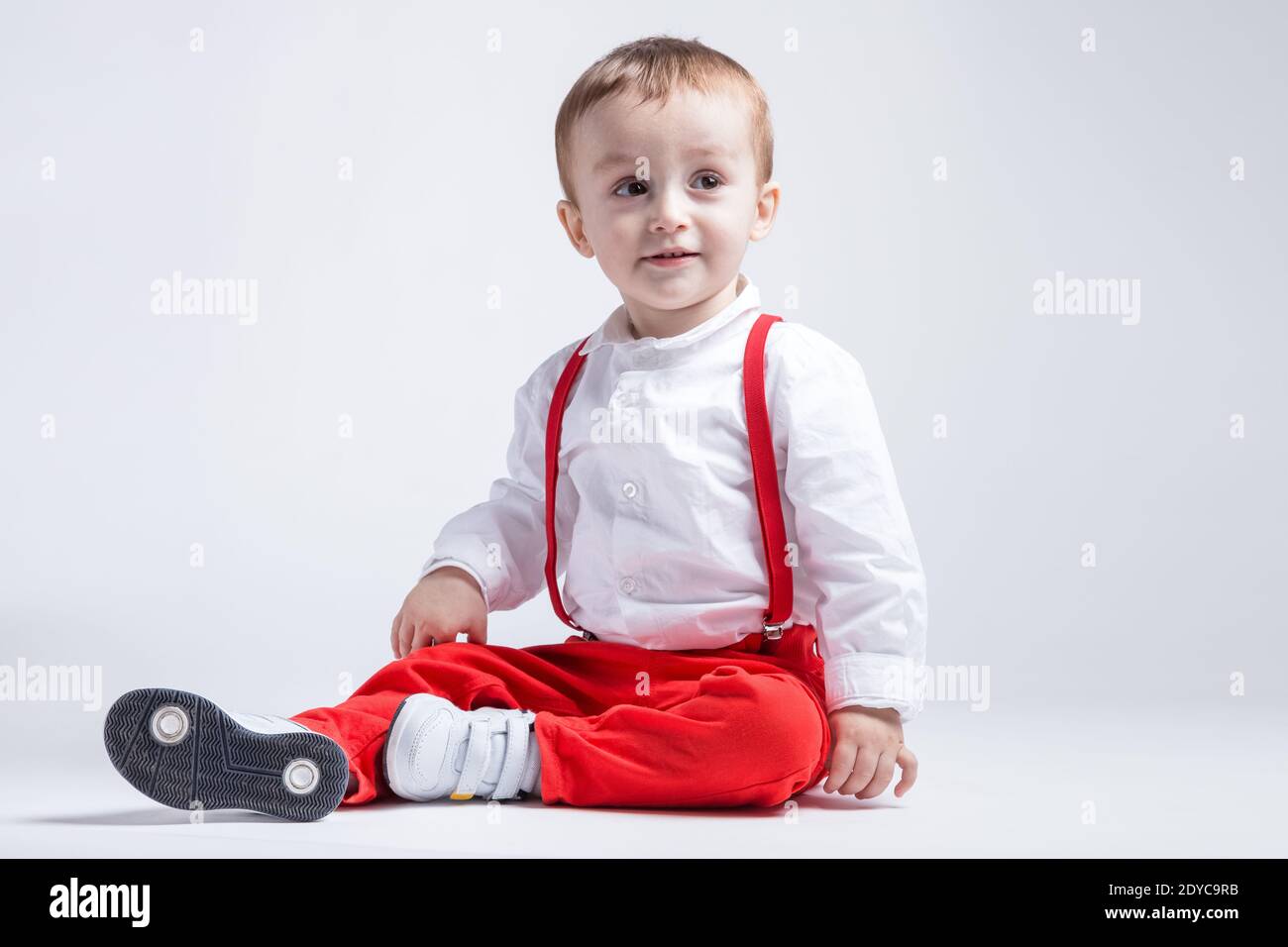 Pretty little boy, dressed in red on white background. Boy and ...