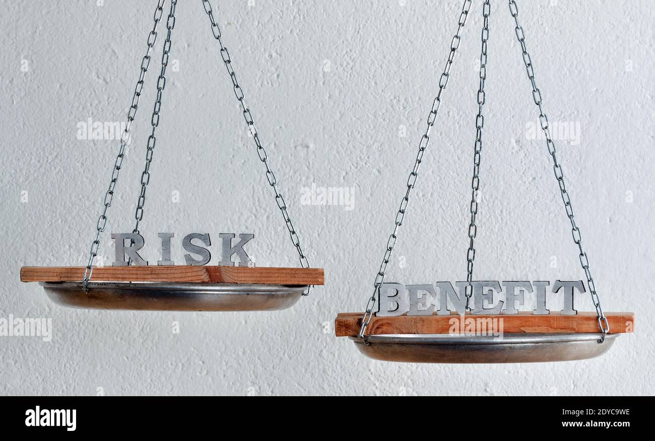 Words Risk and Benefit in balance. Scales on white background . Choice ...