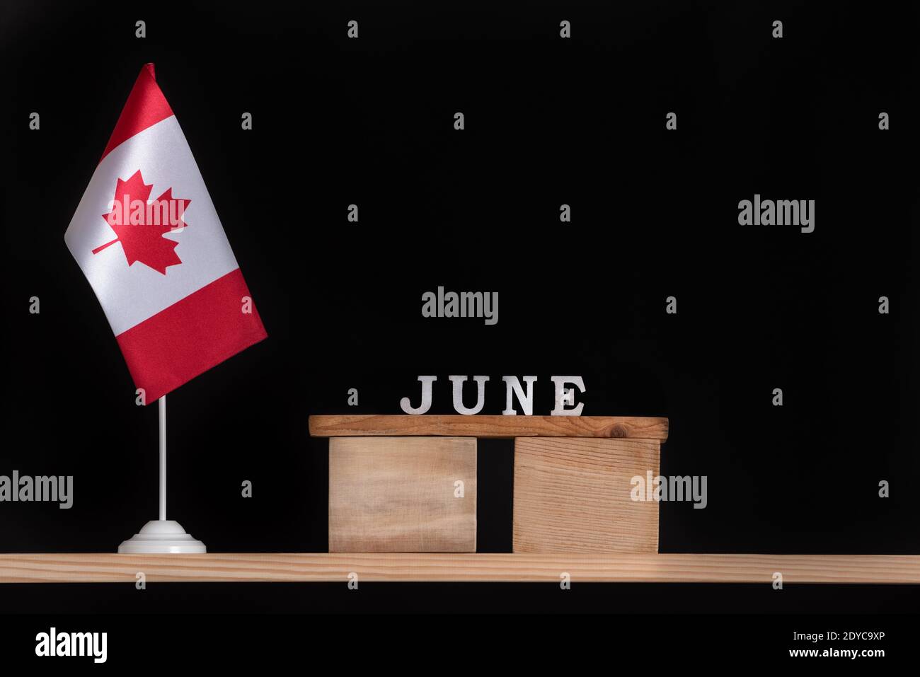 Wooden calendar of June with Canadian flag on black background ...