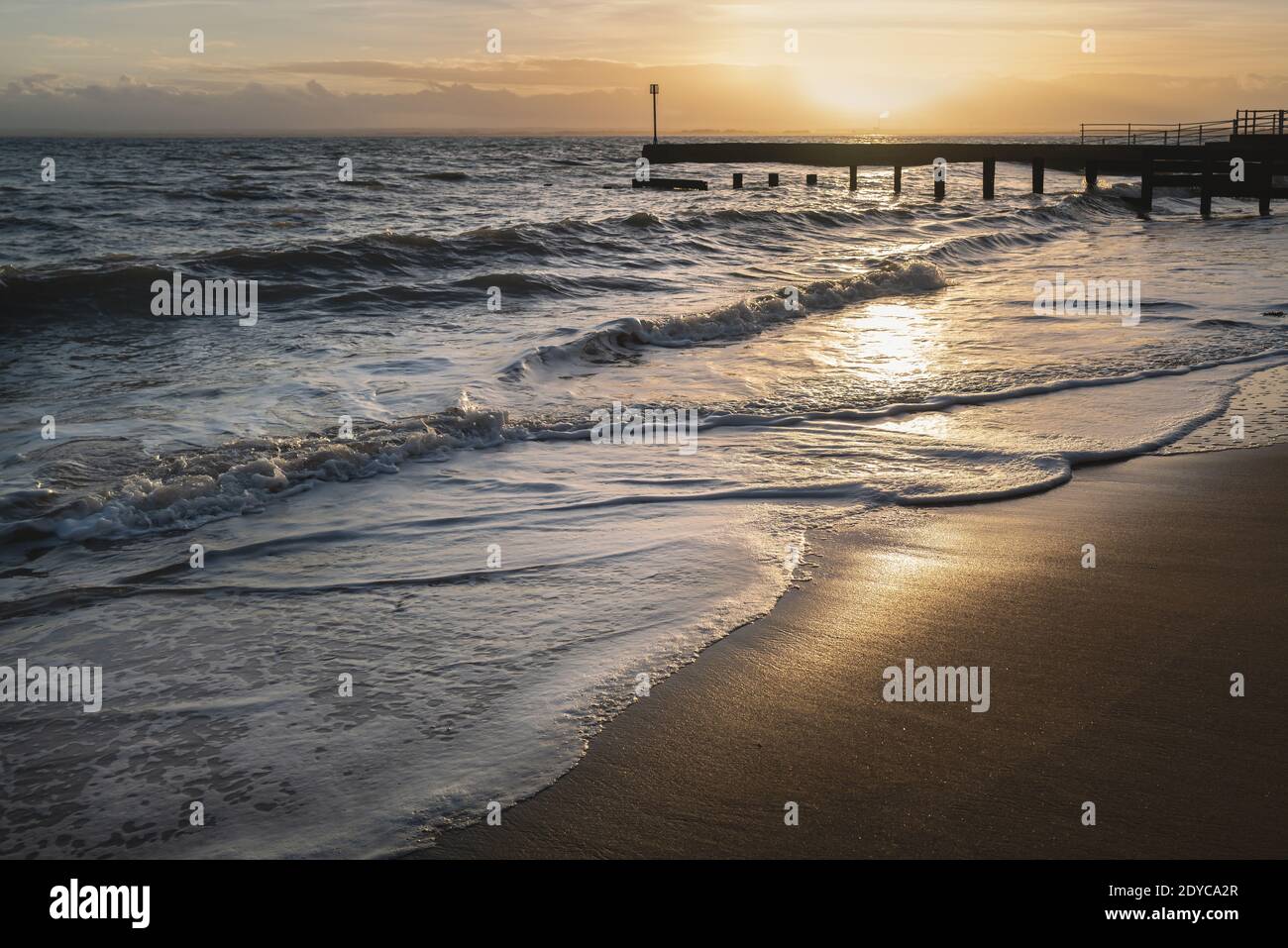 Winter sunset reflecting in the waves on the sandy Western Undercliff ...