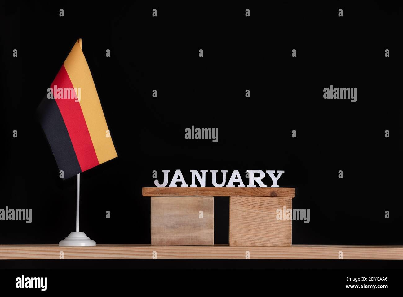 Wooden calendar of January with German flag on black background ...