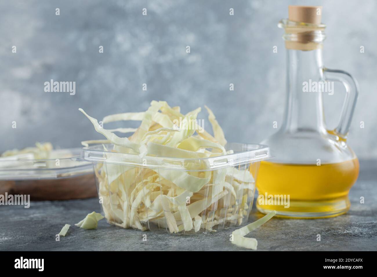 Chopped Green cabbage and bottle of oil on grey background Stock Photo ...