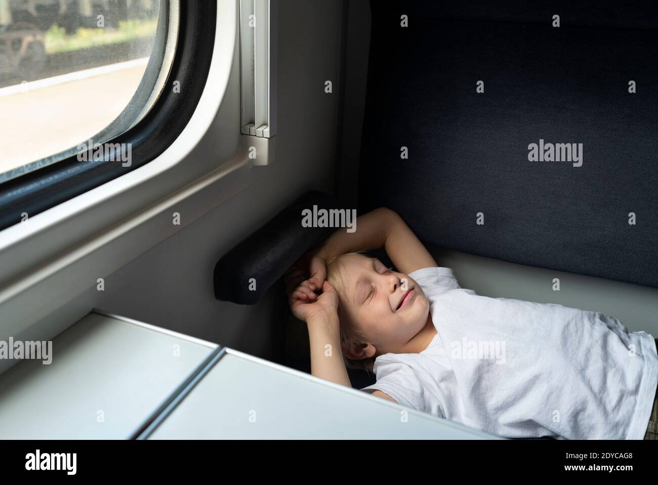 Rail travel. Boy is resting in compartment carriage. Comfortable train ...