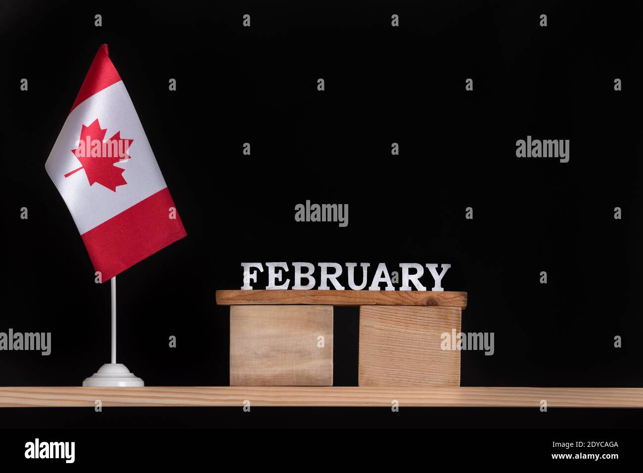 Wooden calendar of February with Canadian flag on black background ...
