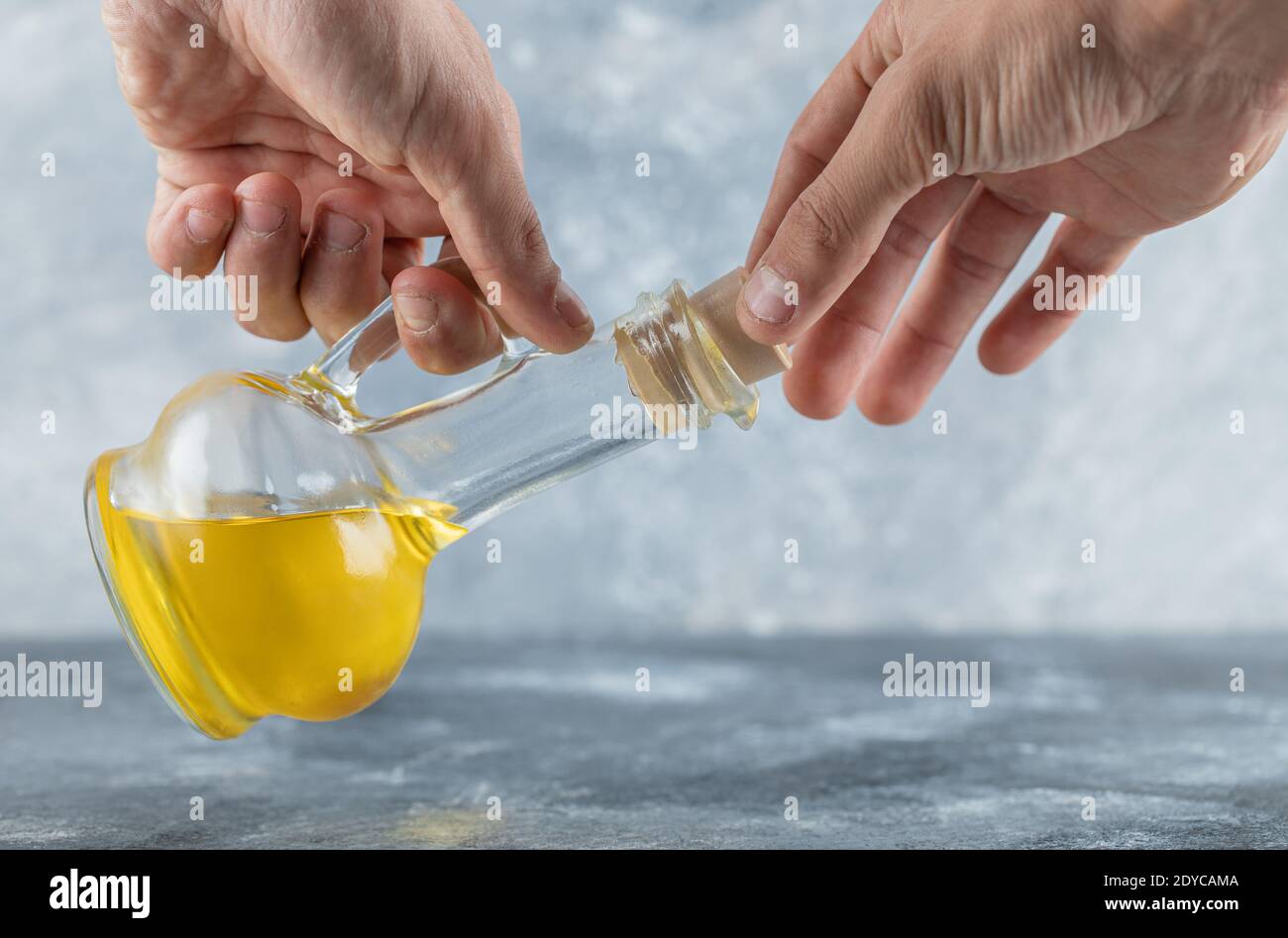 Man trying to openi bottle of oil Stock Photo - Alamy