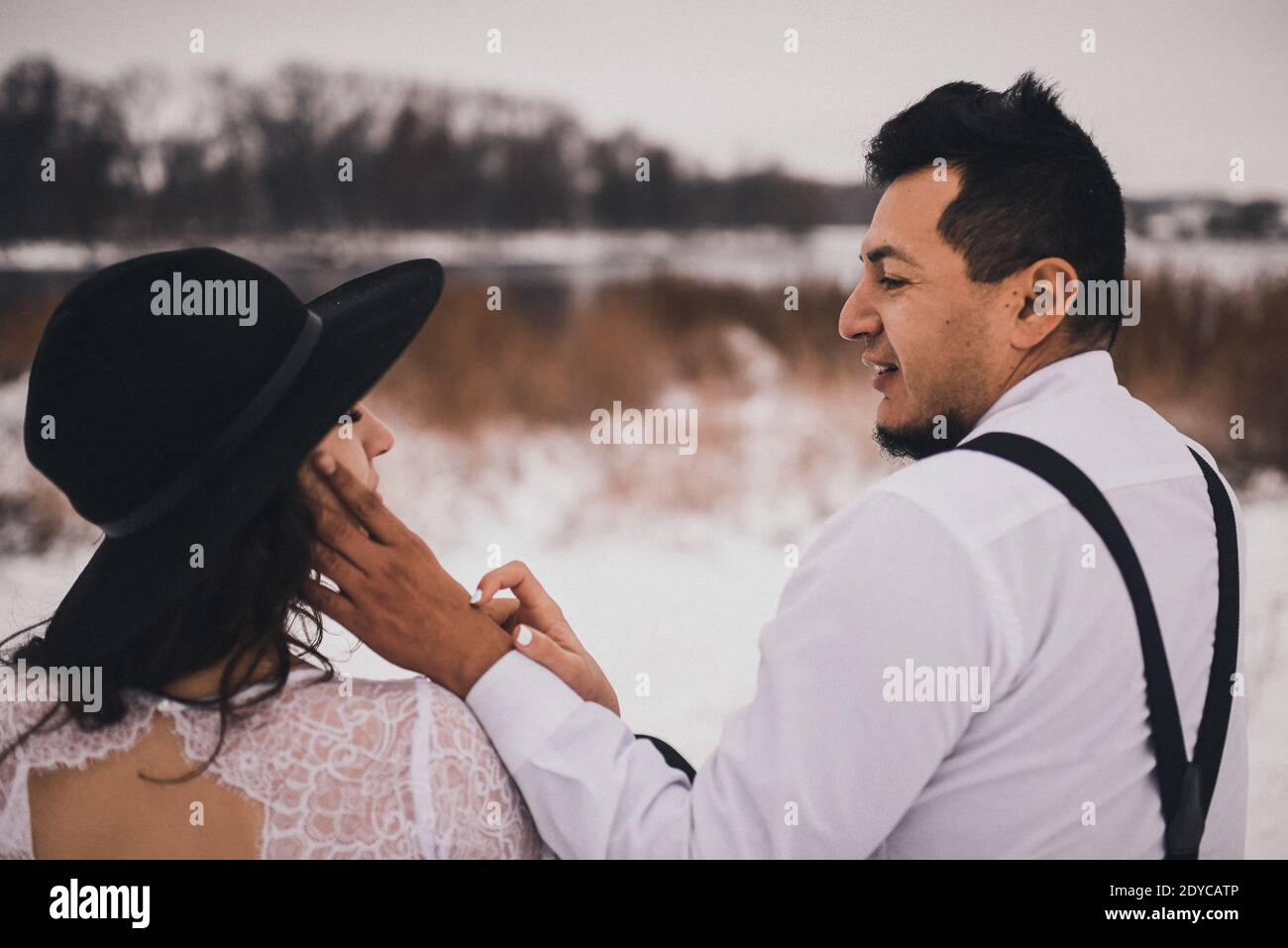 Mexican bride and groom in wedding clothes and suspenders sit on the ...