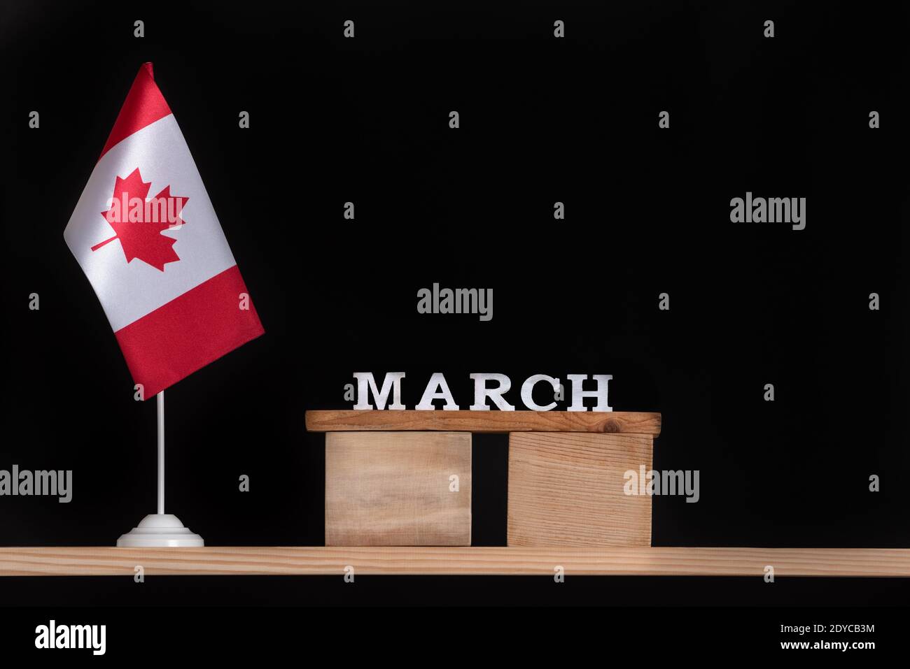 Wooden calendar of March with Canadian flag on black background ...