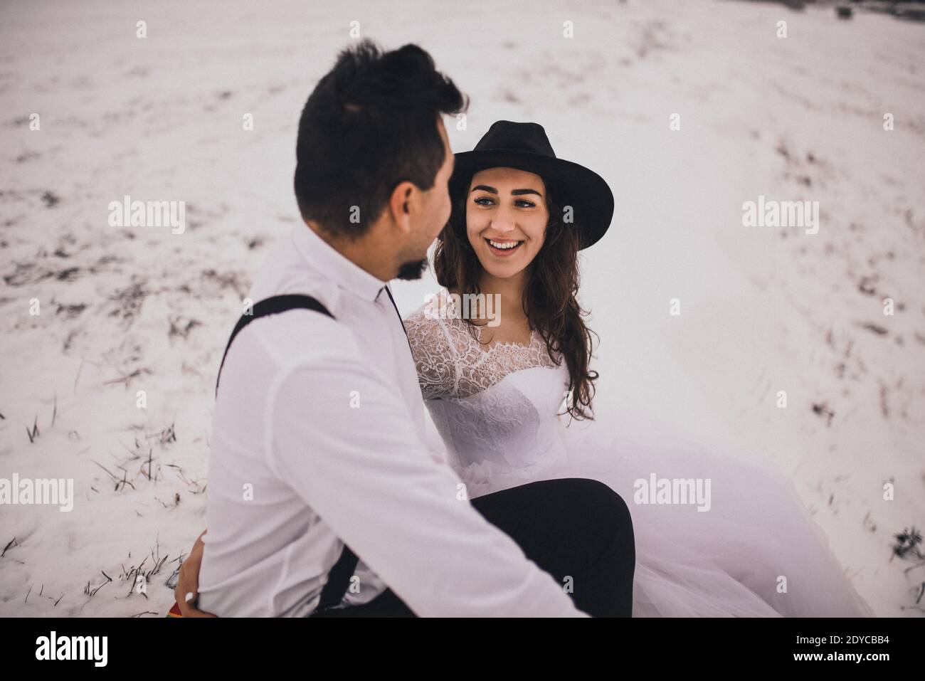 Mexican bride and groom in wedding clothes and suspenders sit on the ...