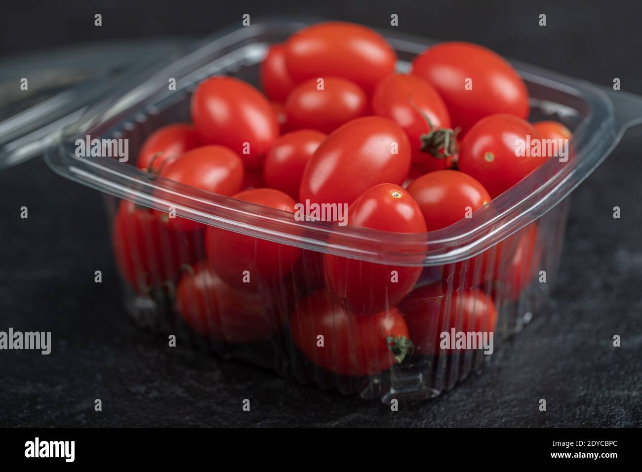Close up photo of small fresh tomatoes in plastic container Stock Photo ...