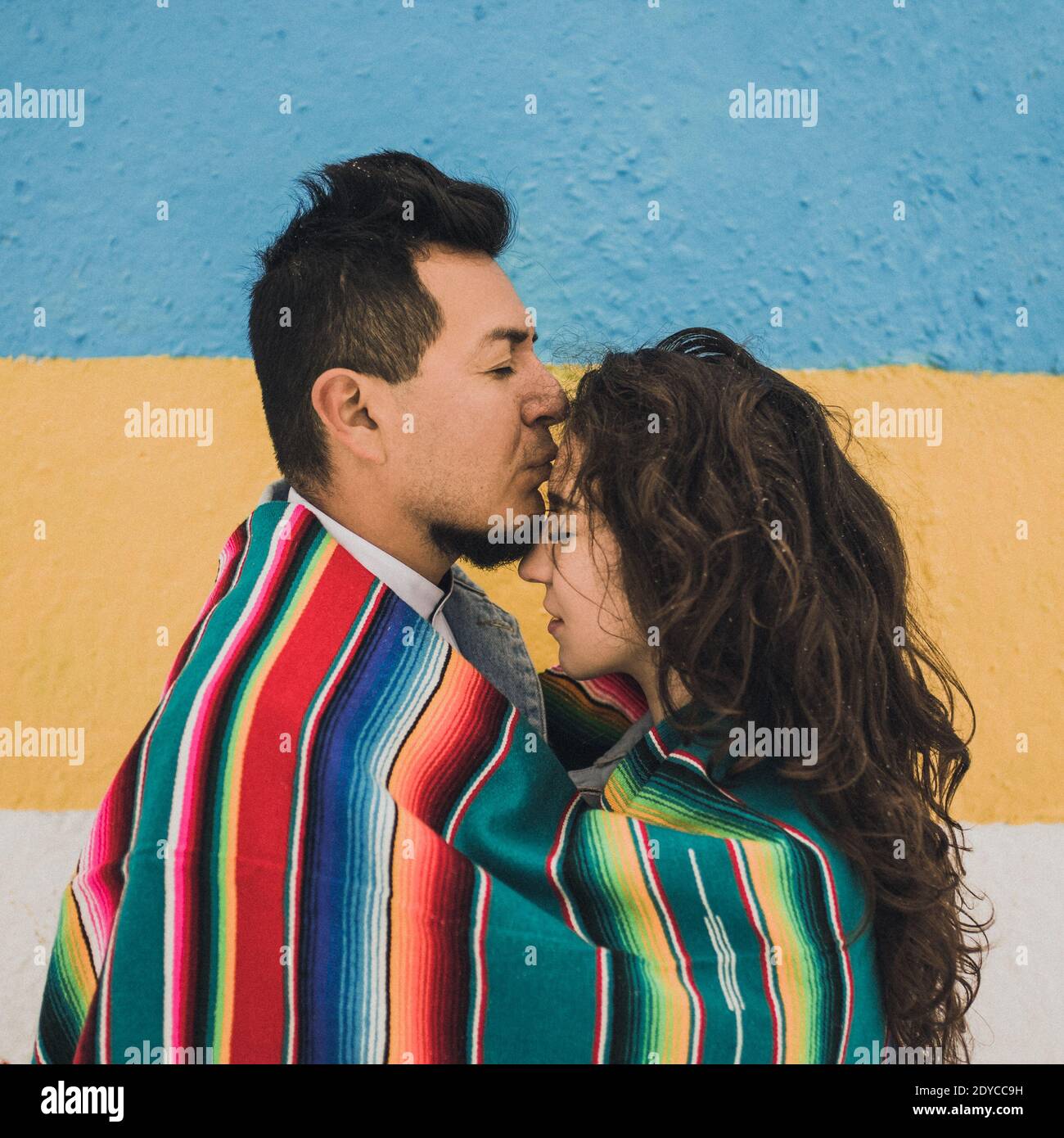 young man and woman kissing hugging. mexican people wrapped covered ...