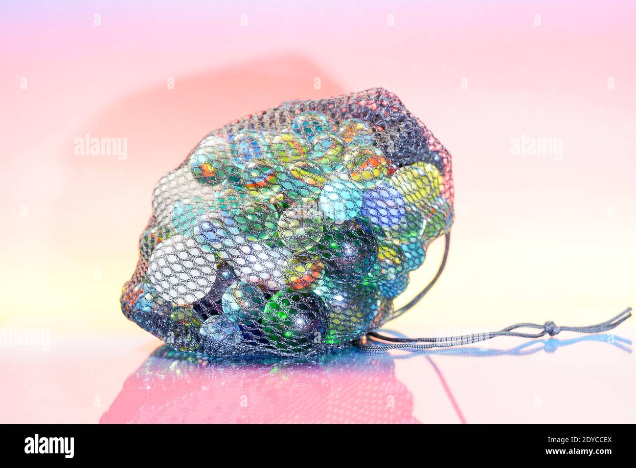 A closeup of a squishy mesh ball reflected on pink surface Stock Photo ...