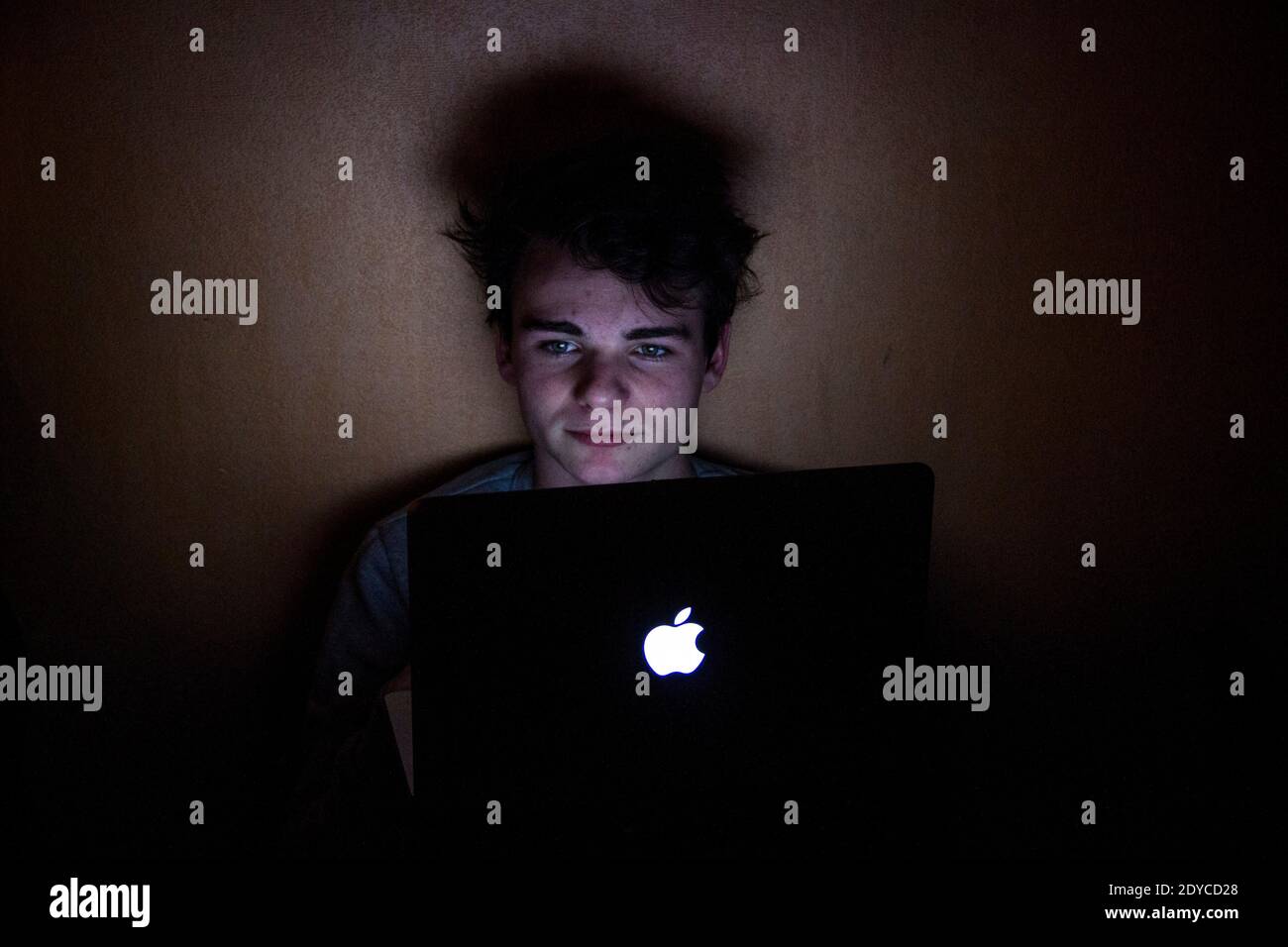 Young man on his computer at night. Jeune homme sur son ordinateur la ...