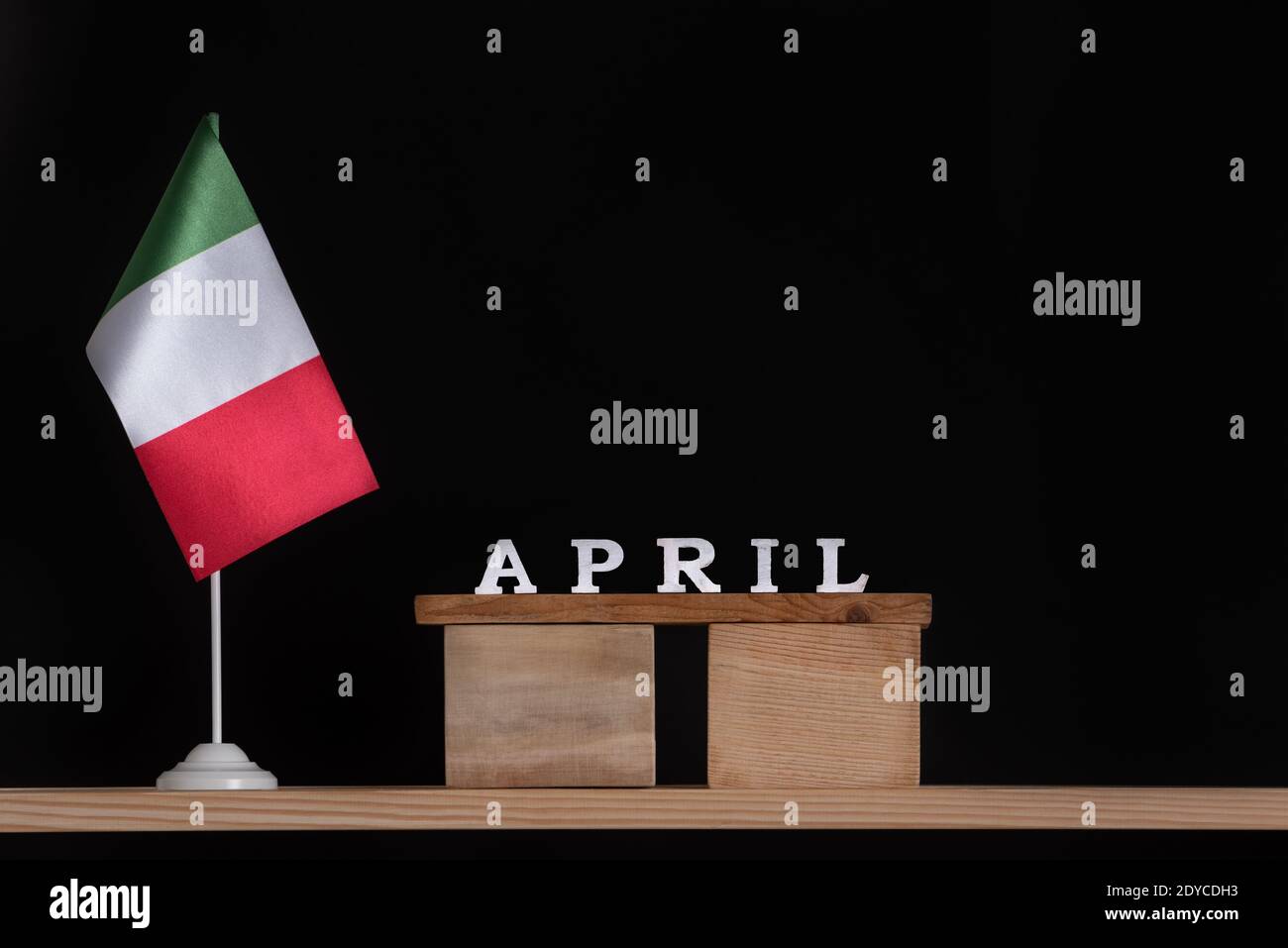 Wooden calendar of April with Italian flag on black background. Dates ...