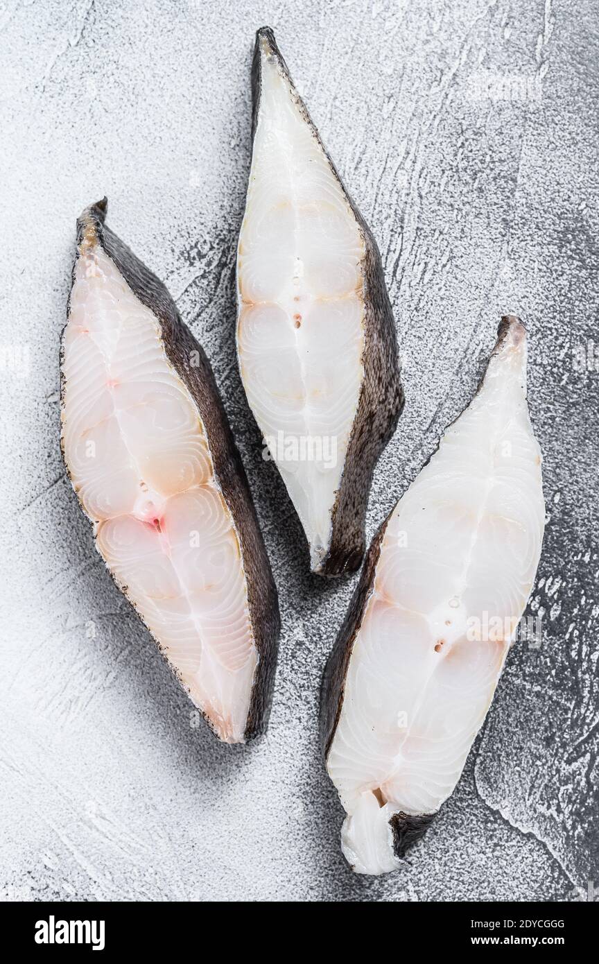 Raw fresh steak fish halibut on the stone table. White background. Top ...