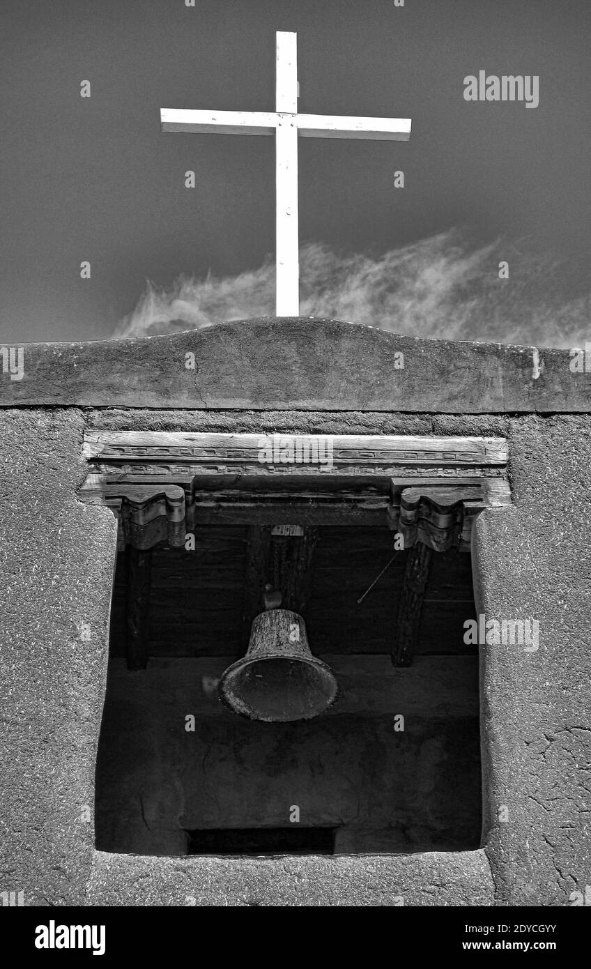 A low angle grayscale shot of a cross on top of a religious building ...