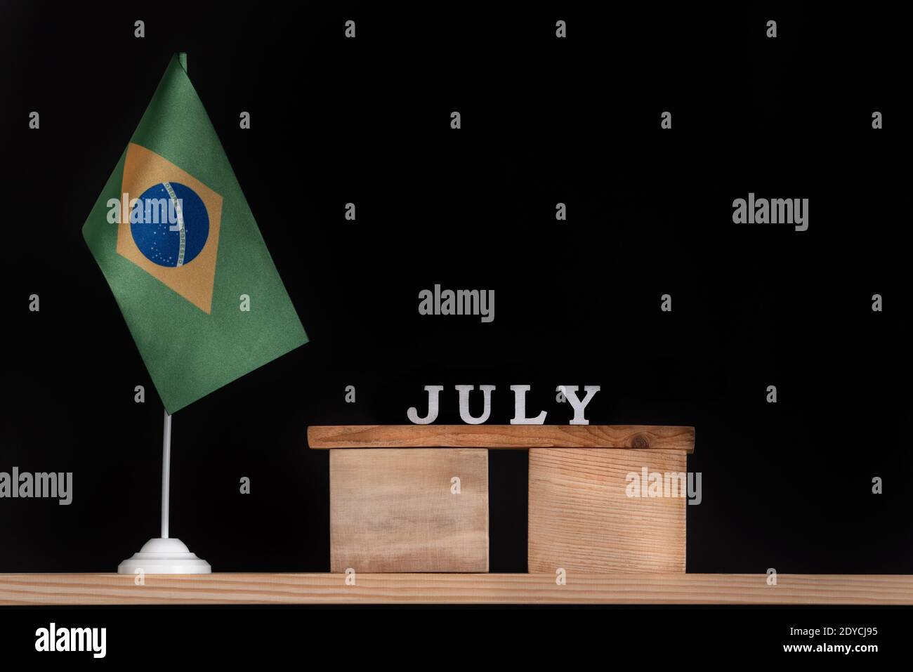 Wooden calendar of July with Brazilian flag on black background. Dates ...