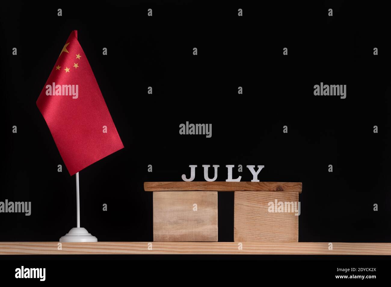 Wooden calendar of July with Chinese flag on black background. Holidays ...