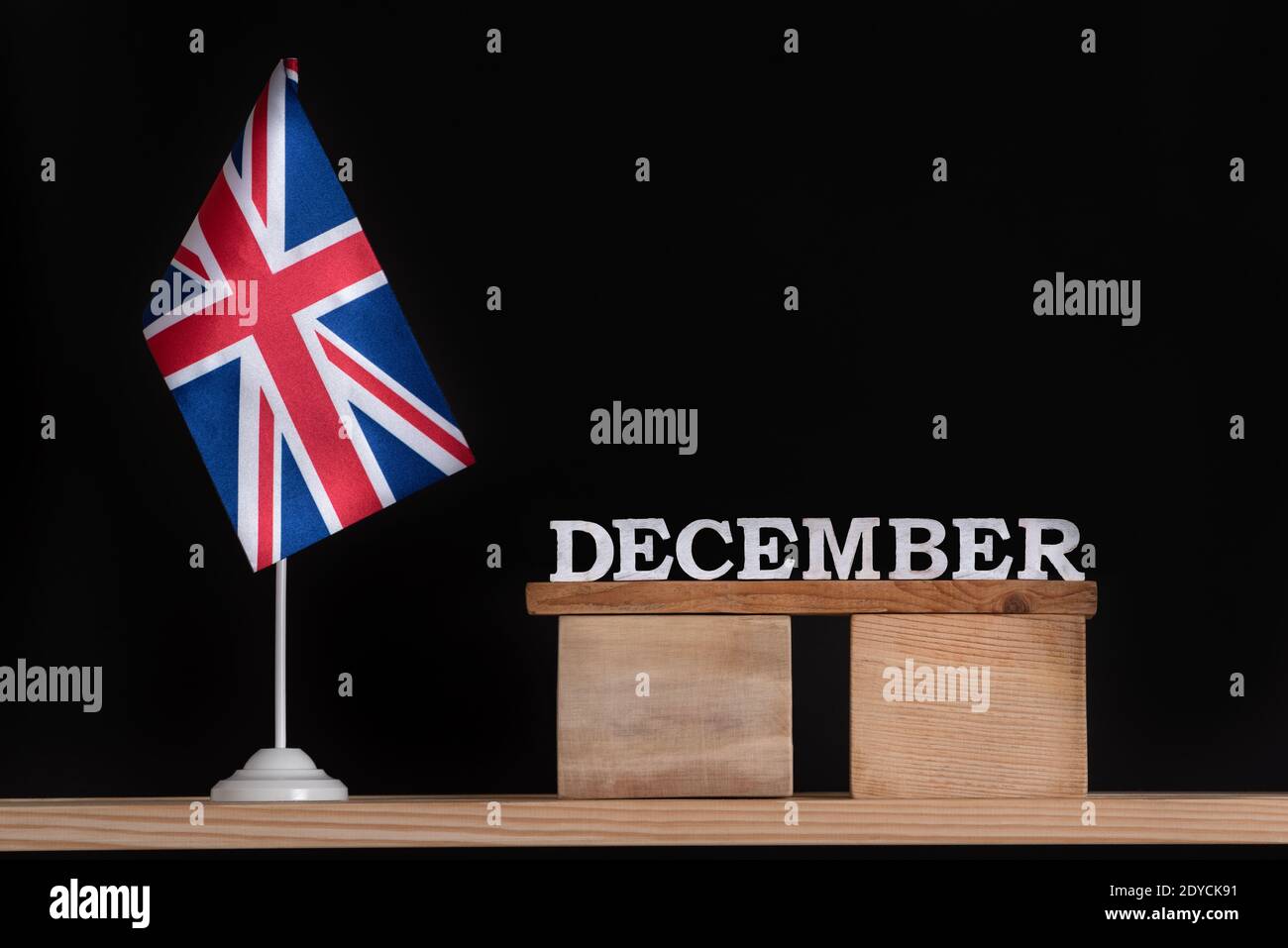 Wooden calendar of December with Great Britain flag on black background ...