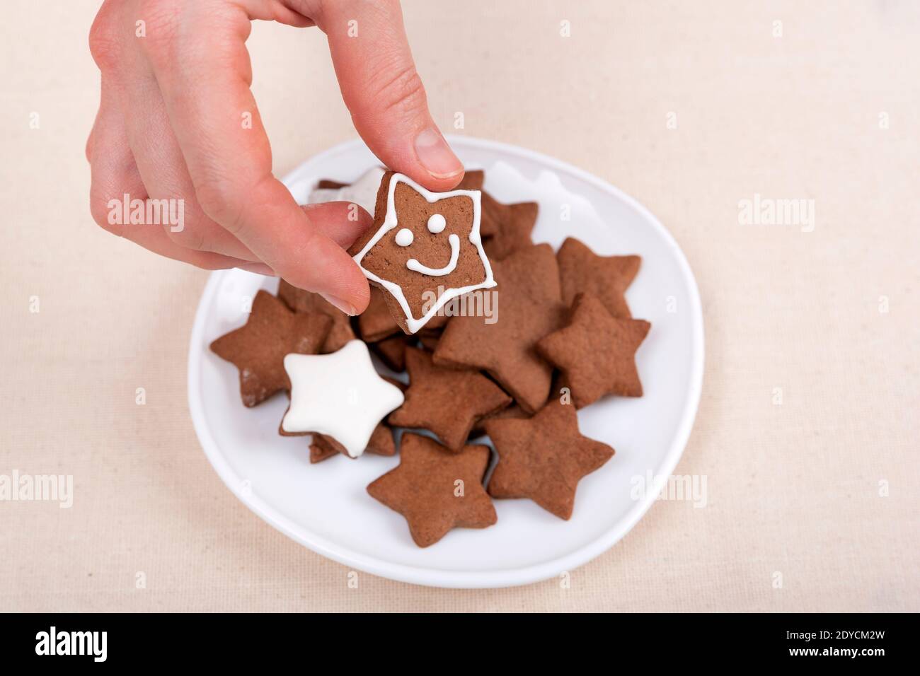 Female hand holds a gingerbread cookie in shape of star emoticon ...