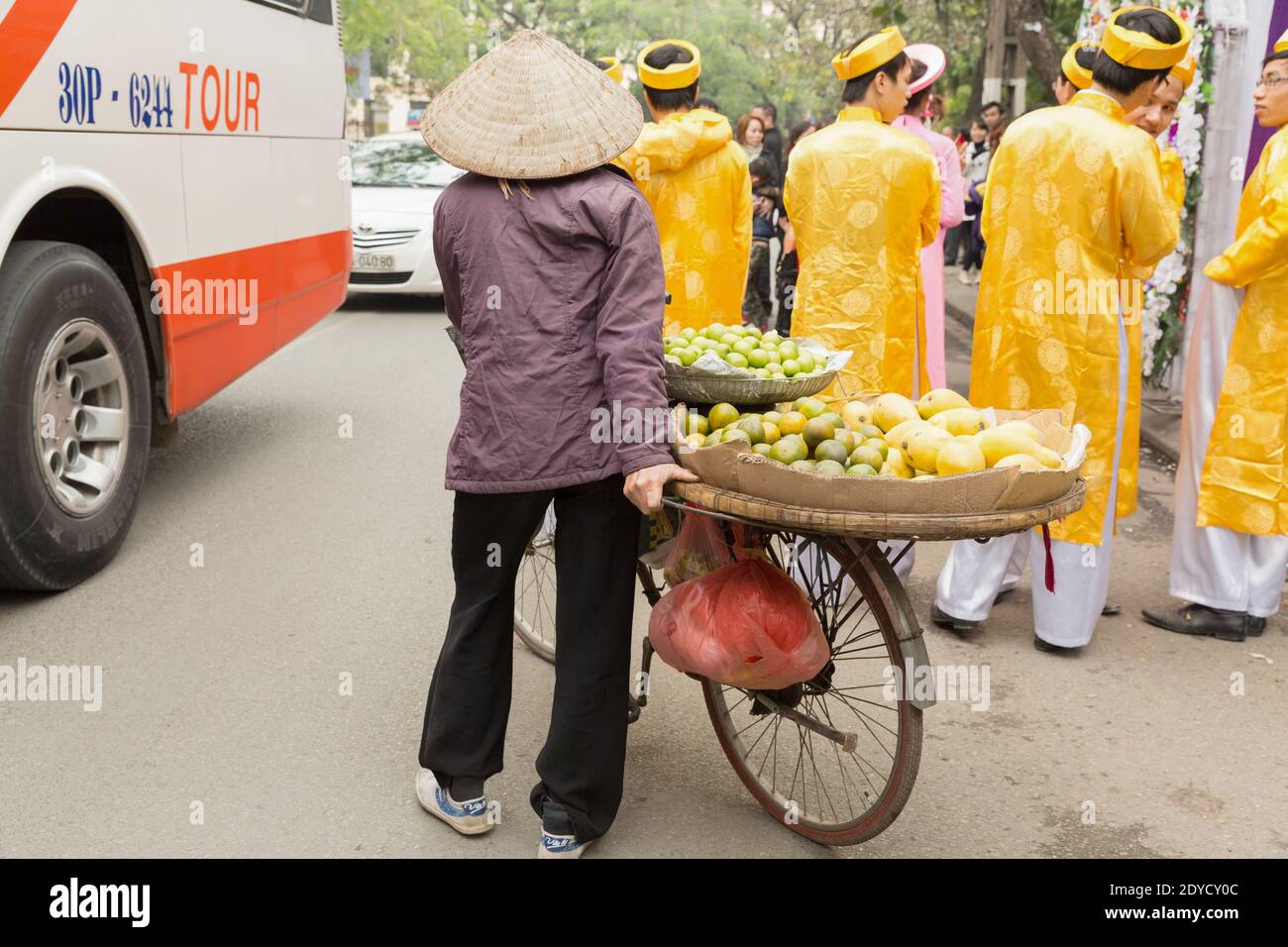 A wedding party assembles to take pictures along a crowded, busy street ...