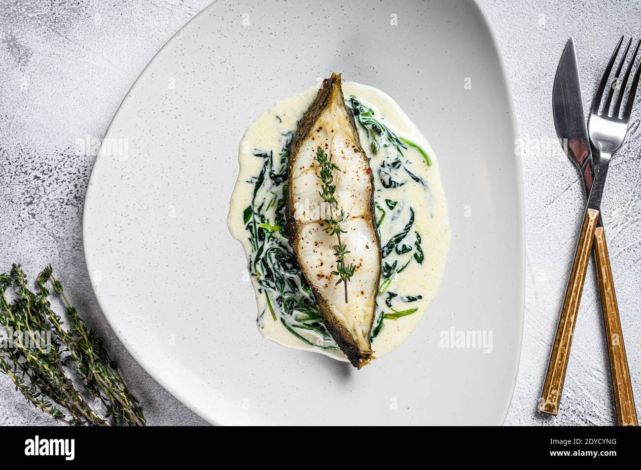 Baked Halibut fish steak with spinach. White background. Top view Stock ...