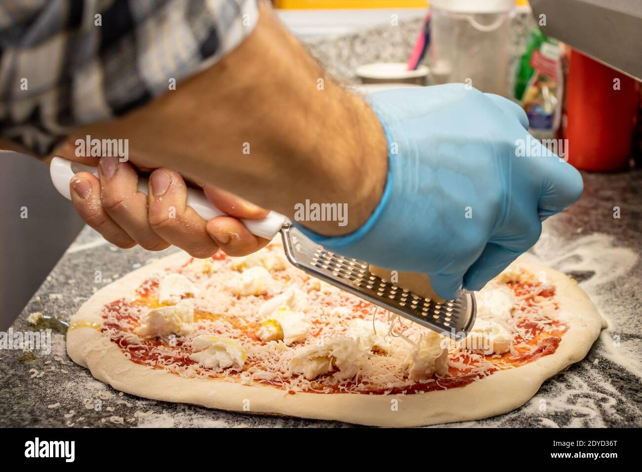 A man making a margherita pizza in a local pizza and gyros restaurant ...