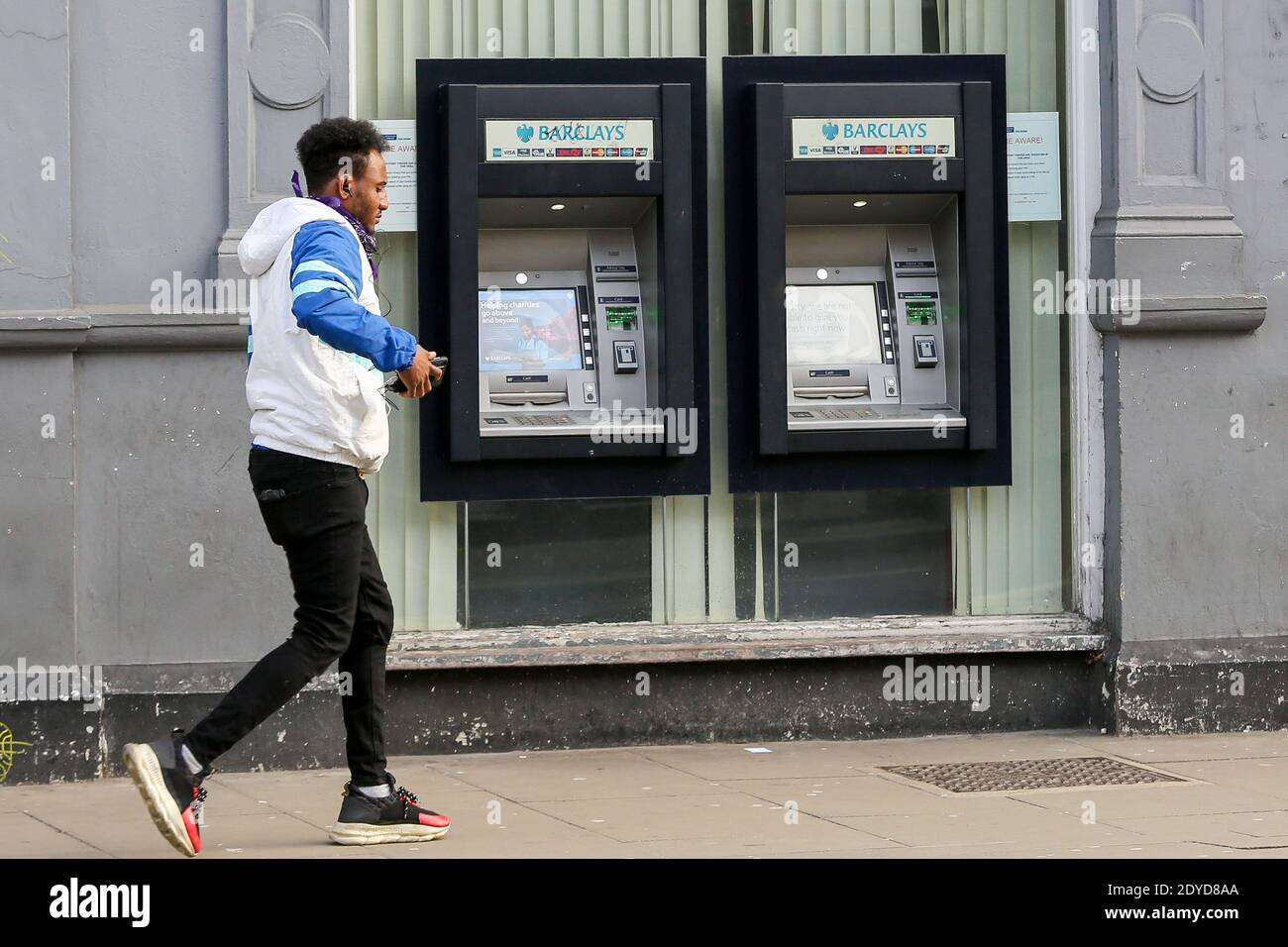 London, UK. 25th Dec, 2020. A man walks past the ATM machines outside a ...