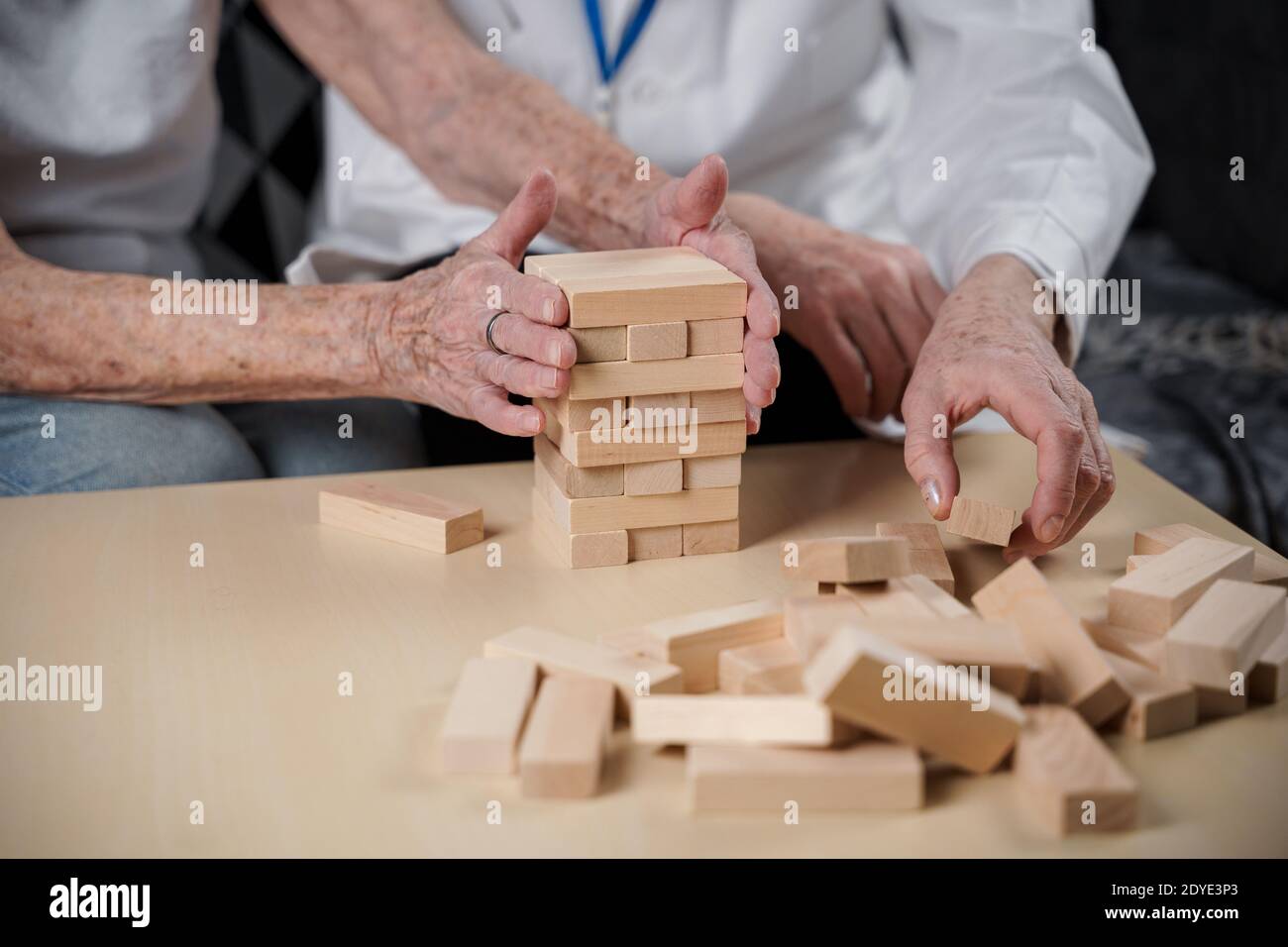 Senior woman practice skills, build wooden blocks, build tower and try ...