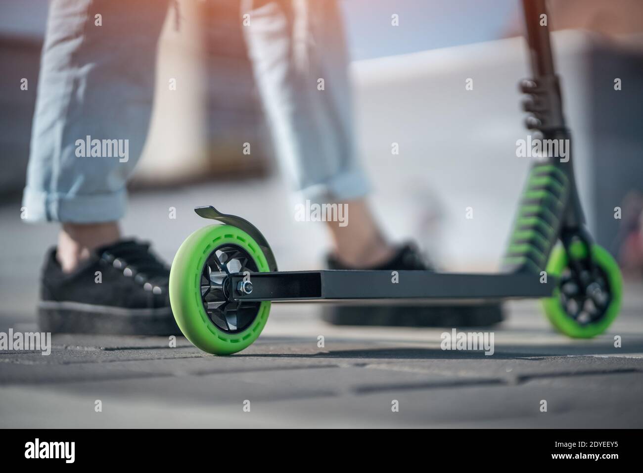young teenager in sneaker on modern extreme stunt kick scooter in ...