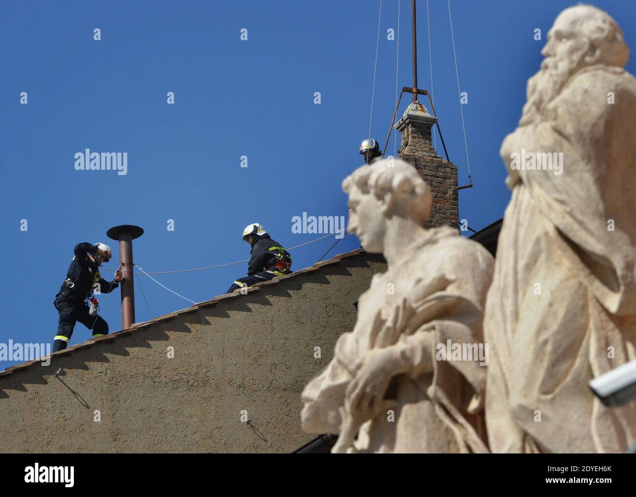 Vatican's firefighters setup the chimney on the roof of the Sistine ...