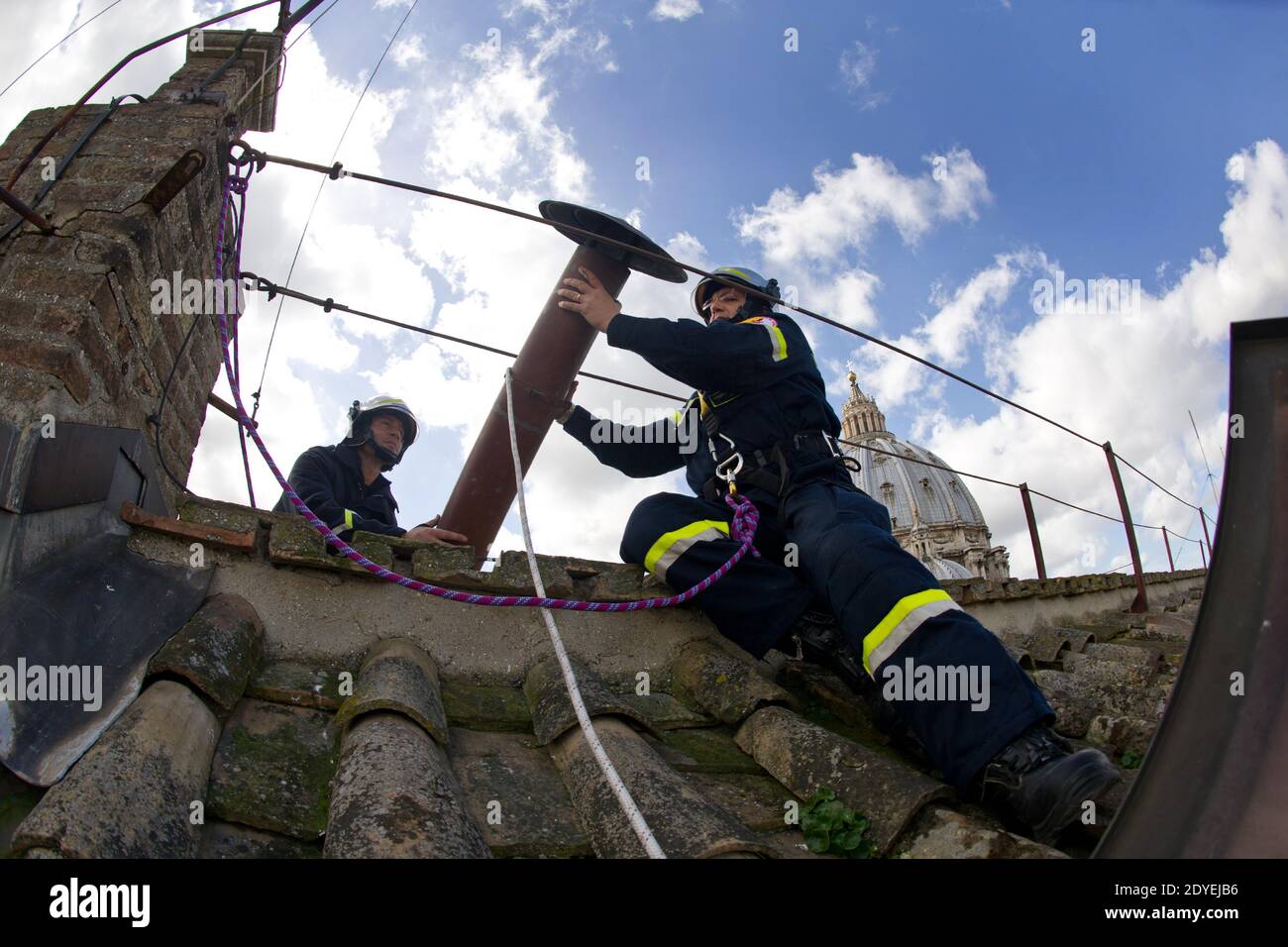 Vatican's firefighters setup the chimney on the roof of the Sistine ...