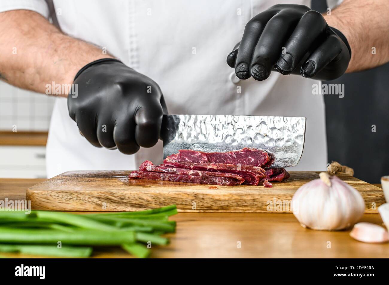 Man cutting raw beef meat. A chef in black gloves. Concept of cooking ...