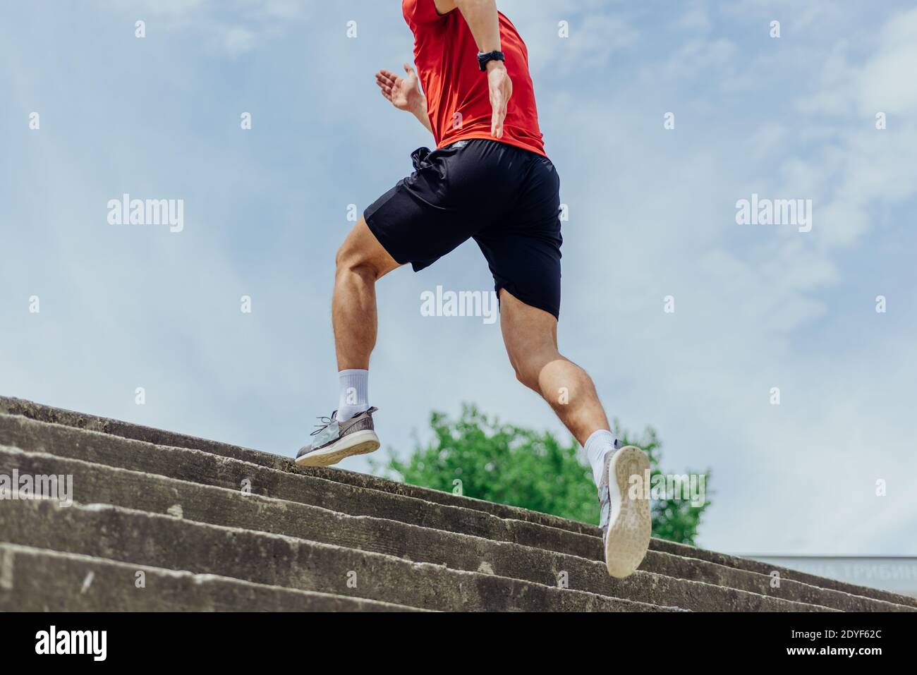 Fit male athlete performing stairs workout, running up climbing stairs ...