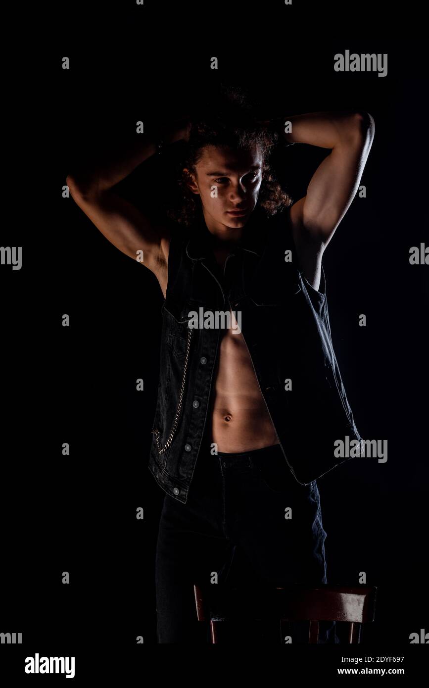 Body shot of an attractive male punk model posing isolated on black ...