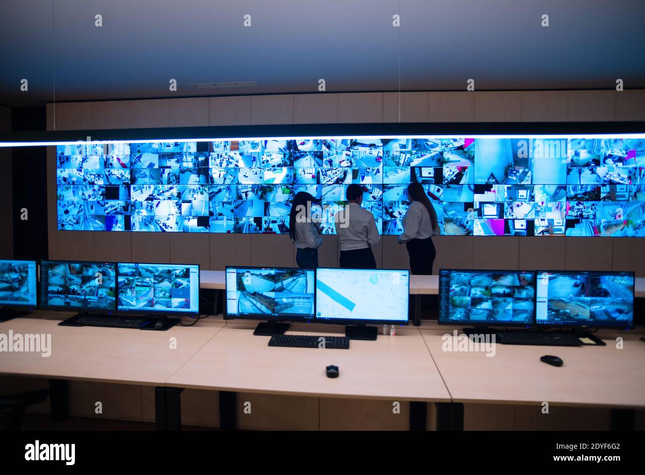 Security guards standing in front of a large CCTV monitor at the main ...