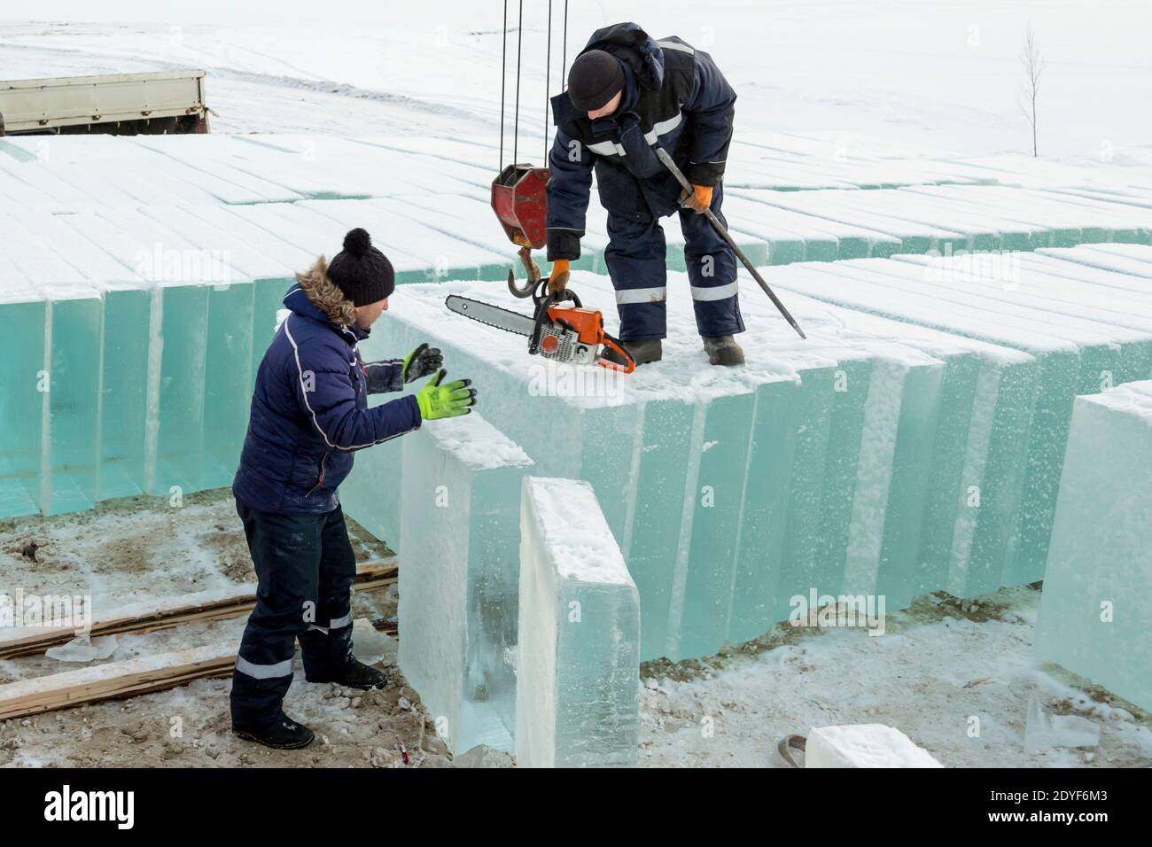 Workers prepare large ice slabs for loading to build an ice town Stock ...