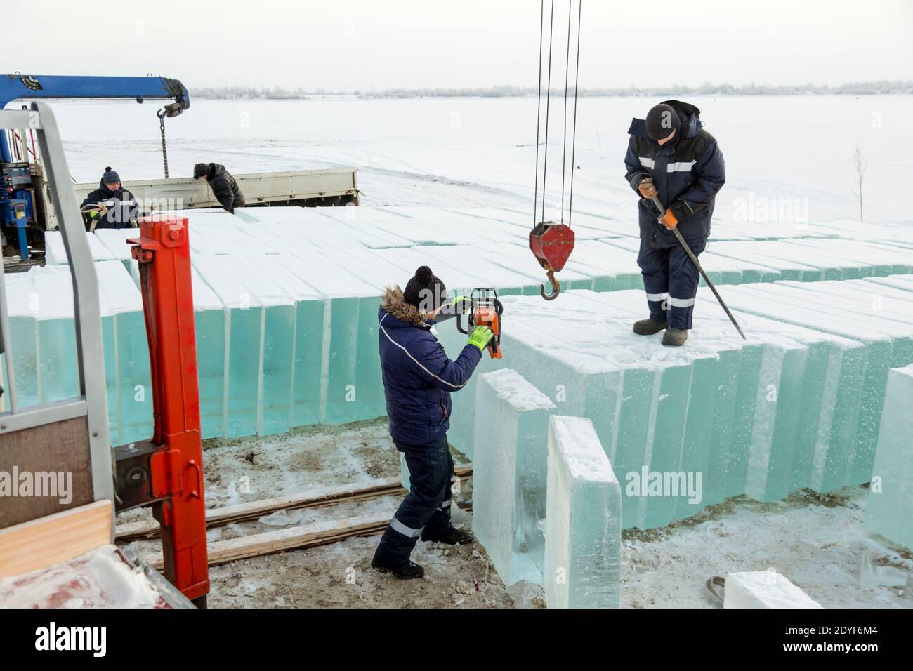 Workers prepare large ice slabs for loading to build an ice town Stock ...