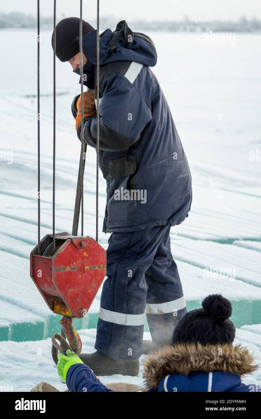 Workers prepare large ice slabs for loading to build an ice town Stock ...