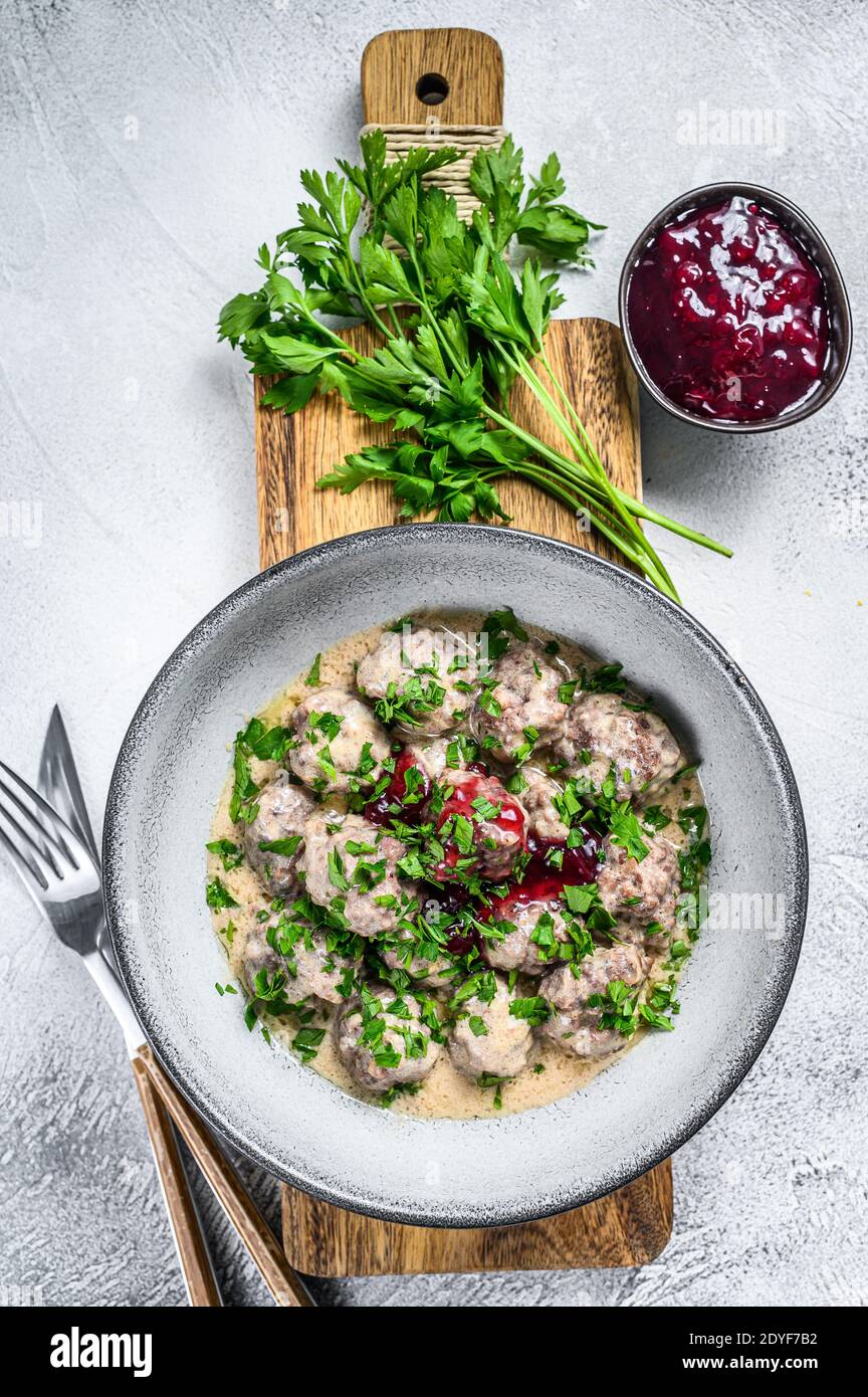 Mince meat meatballs with cream sauce on a plate. White wooden ...