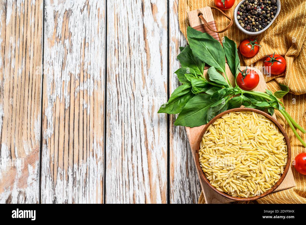 uncooked Orzo paste. Recipe for risoni with Basil leaves, tomatoes and ...