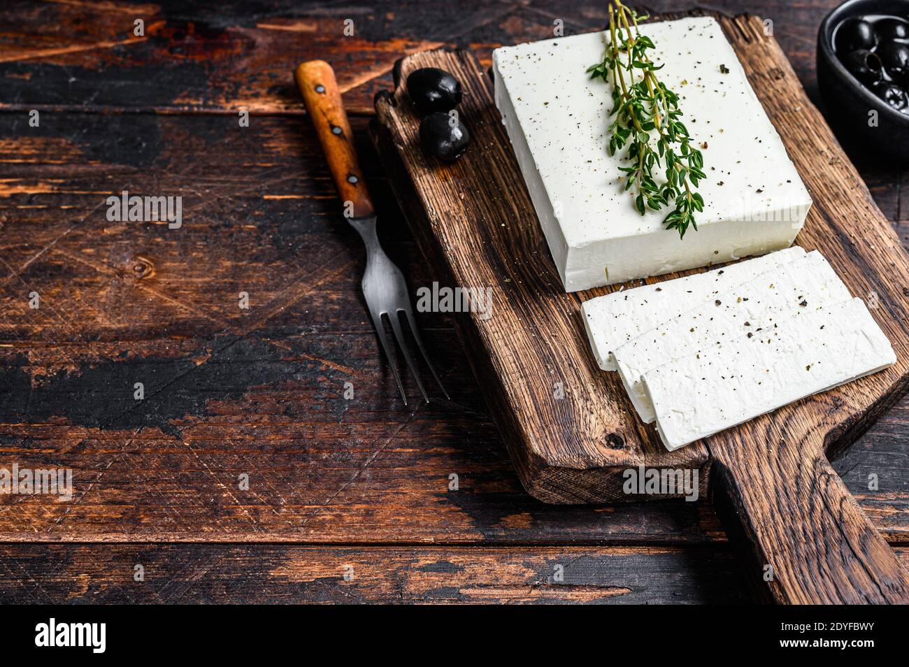 Fresh cheese feta with thyme and olives. Dark wooden background. Top ...