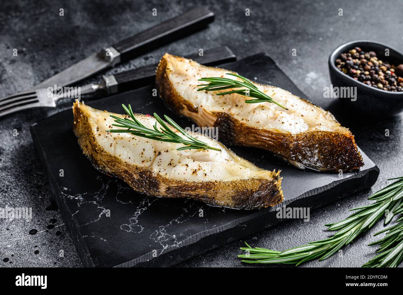 Baked halibut fish steak. Black background. Top view Stock Photo - Alamy