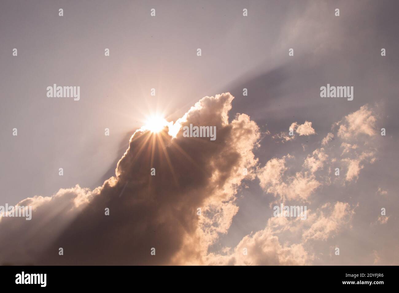 A low angle shot of the beautiful sky with the sun shining from behind ...