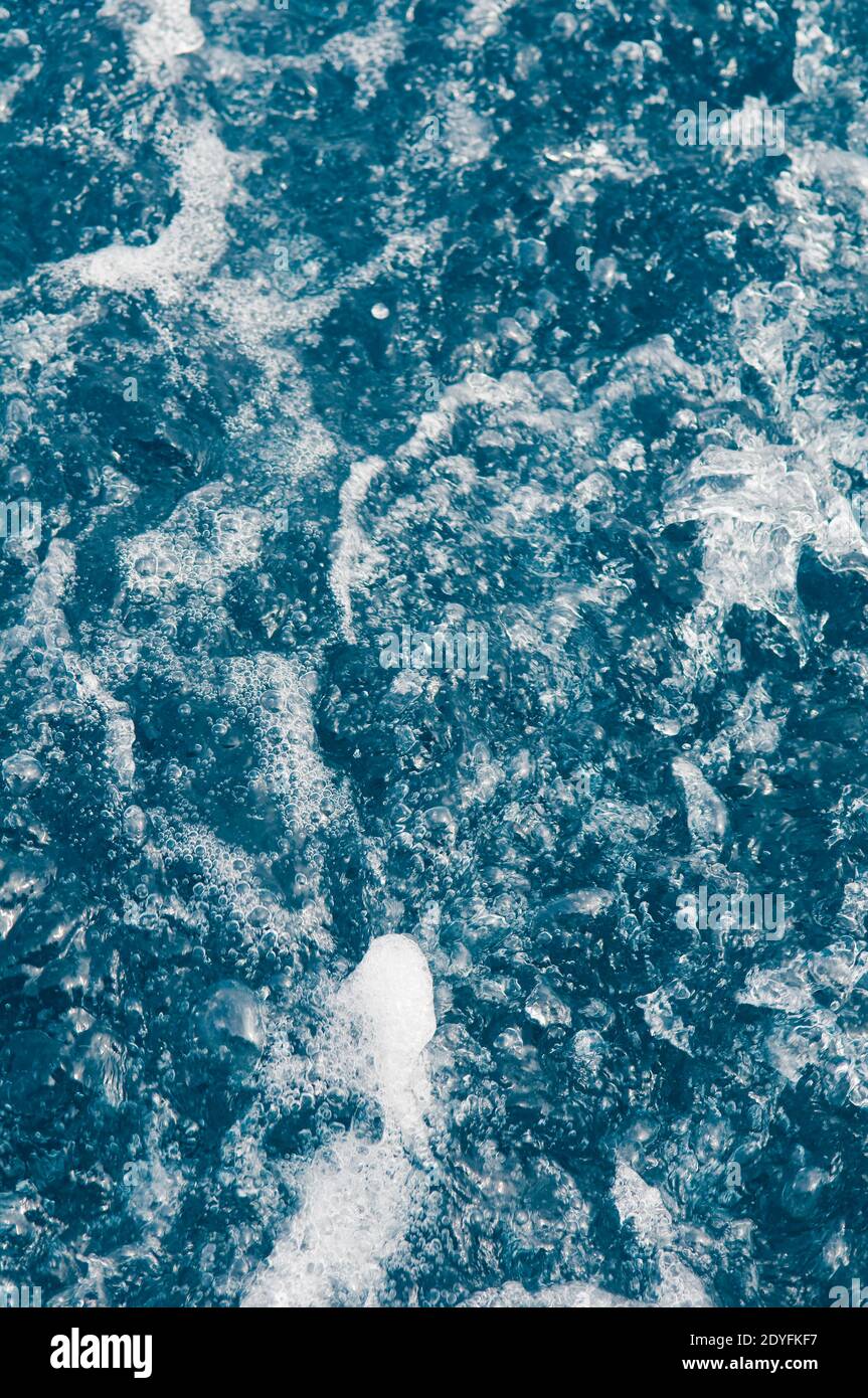 Bubble sea water surface background close-up. Rapid blue splashing ...