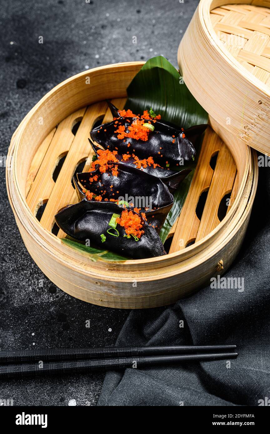 Black Dim sum dumplings in bamboo steamer. Asian cuisine. Black ...